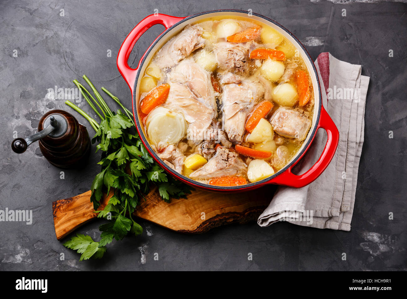 Stewed rabbit with potatoes and carrot in cast iron pot on concrete ...