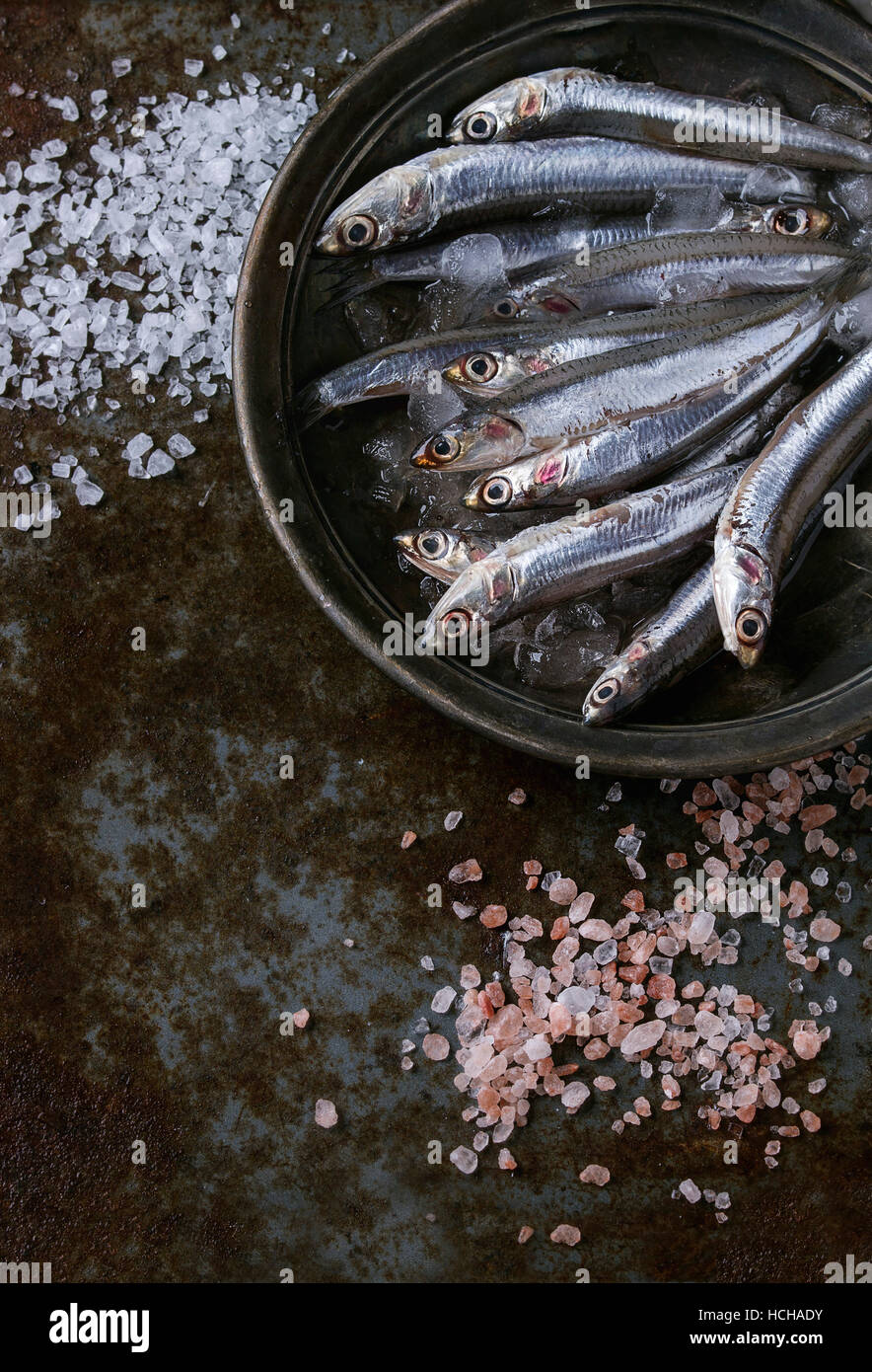 Lot of raw fresh anchovies fishes on crushed ice in vintage plate with ...
