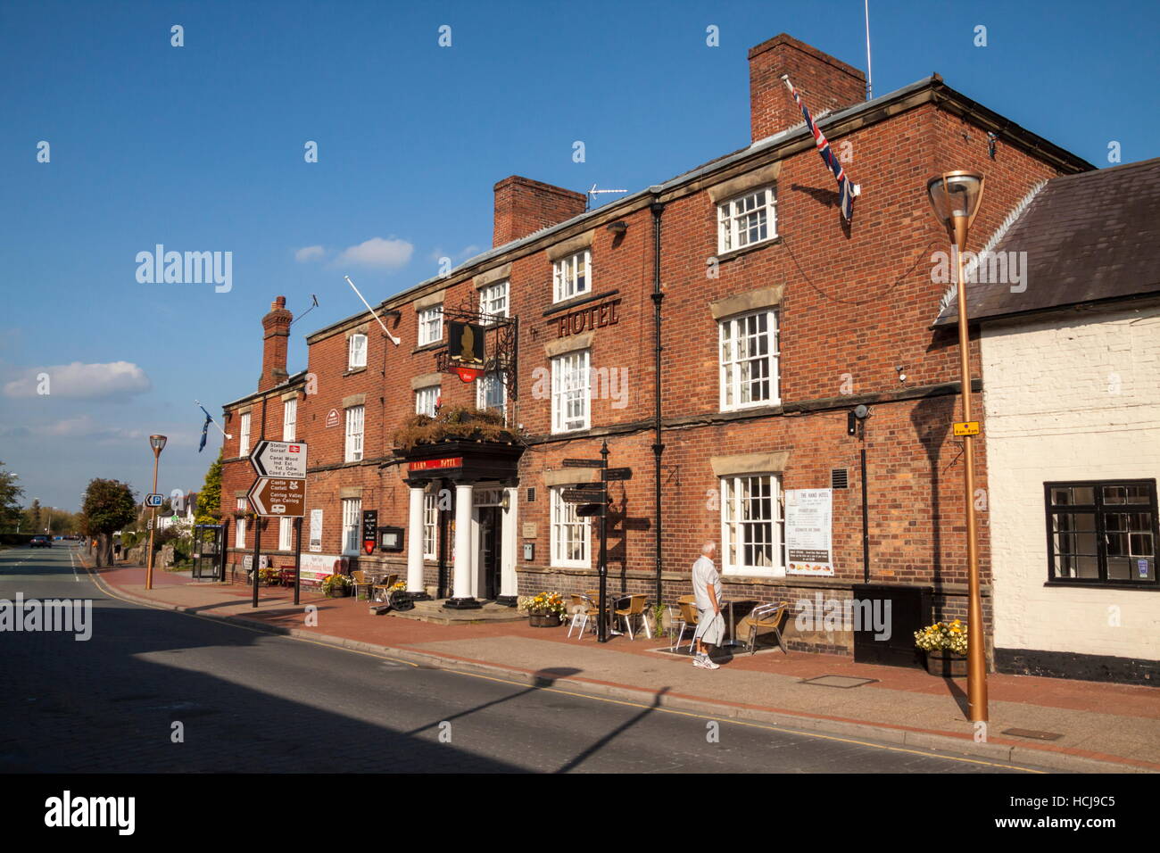 A man looking at the menu on the outside wall of the Hand Hotel, Chirk ...