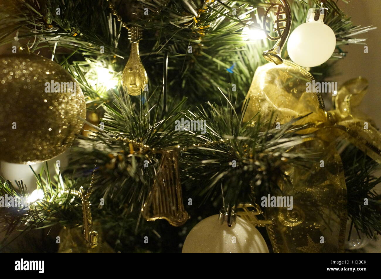 Macro view of Christmas tree with golden balls and music instruments as ...