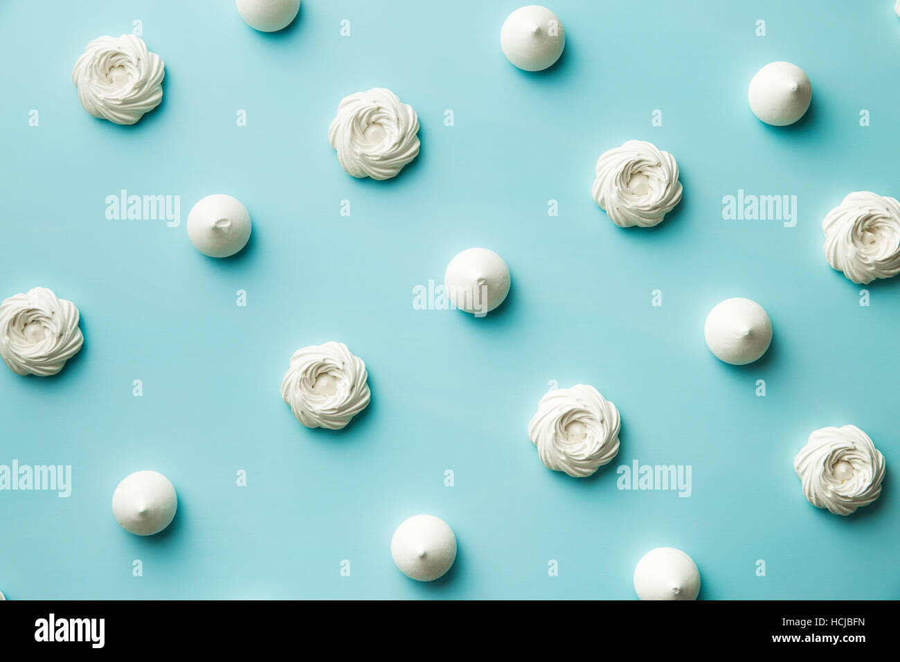 Sweet white meringue on blue background Stock Photo - Alamy