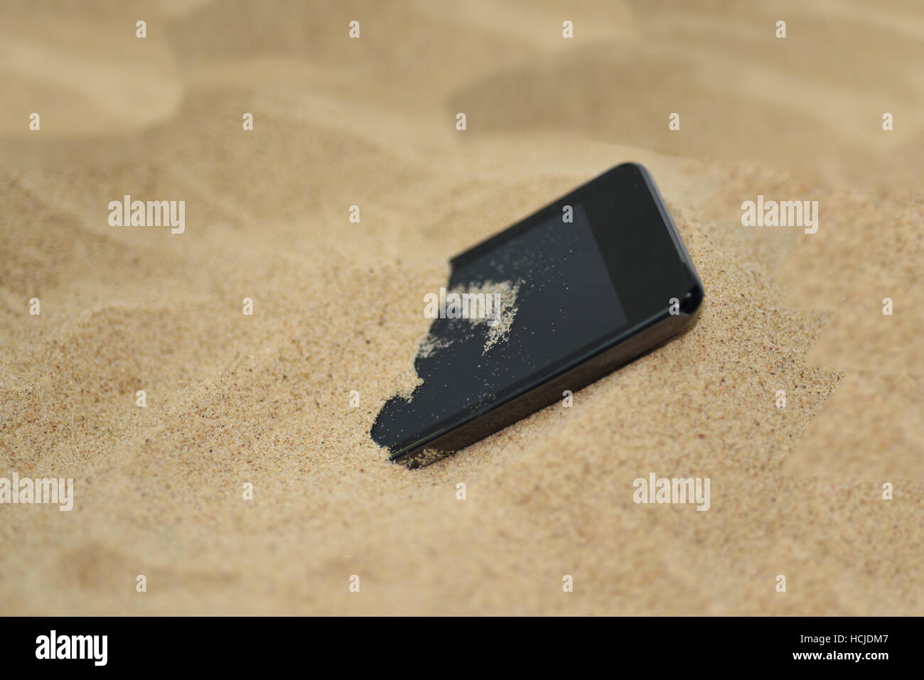 Mobile phone in sand Stock Photo - Alamy
