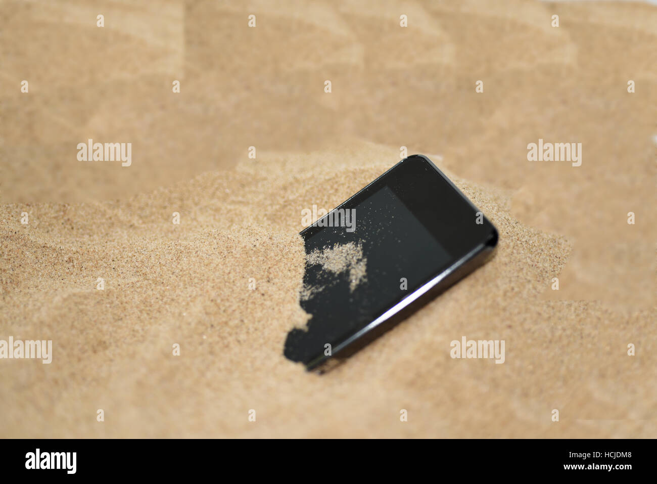 Mobile phone in sand Stock Photo - Alamy