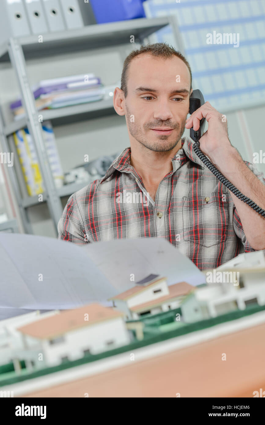 Architect sat with model house Stock Photo - Alamy