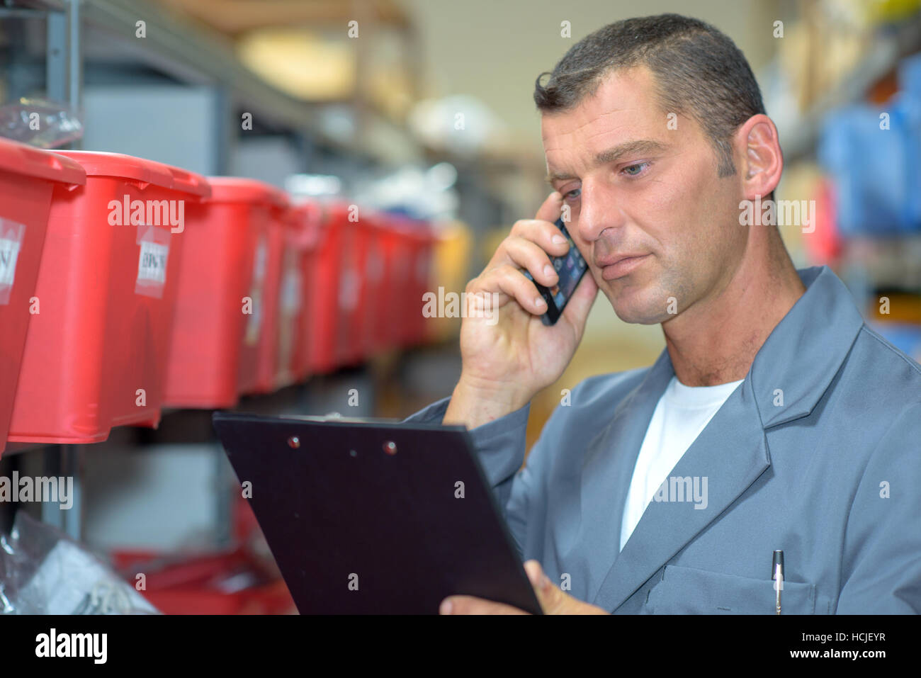Man holding clipboard, on telephone Stock Photo - Alamy