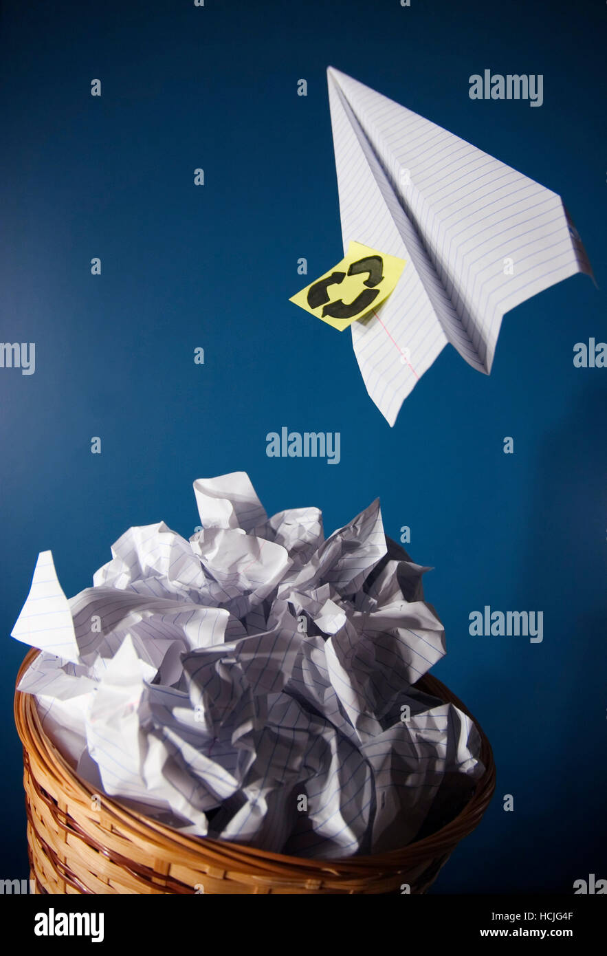 A paper airplane with the recycle symbol drawn onto a small post-it ...