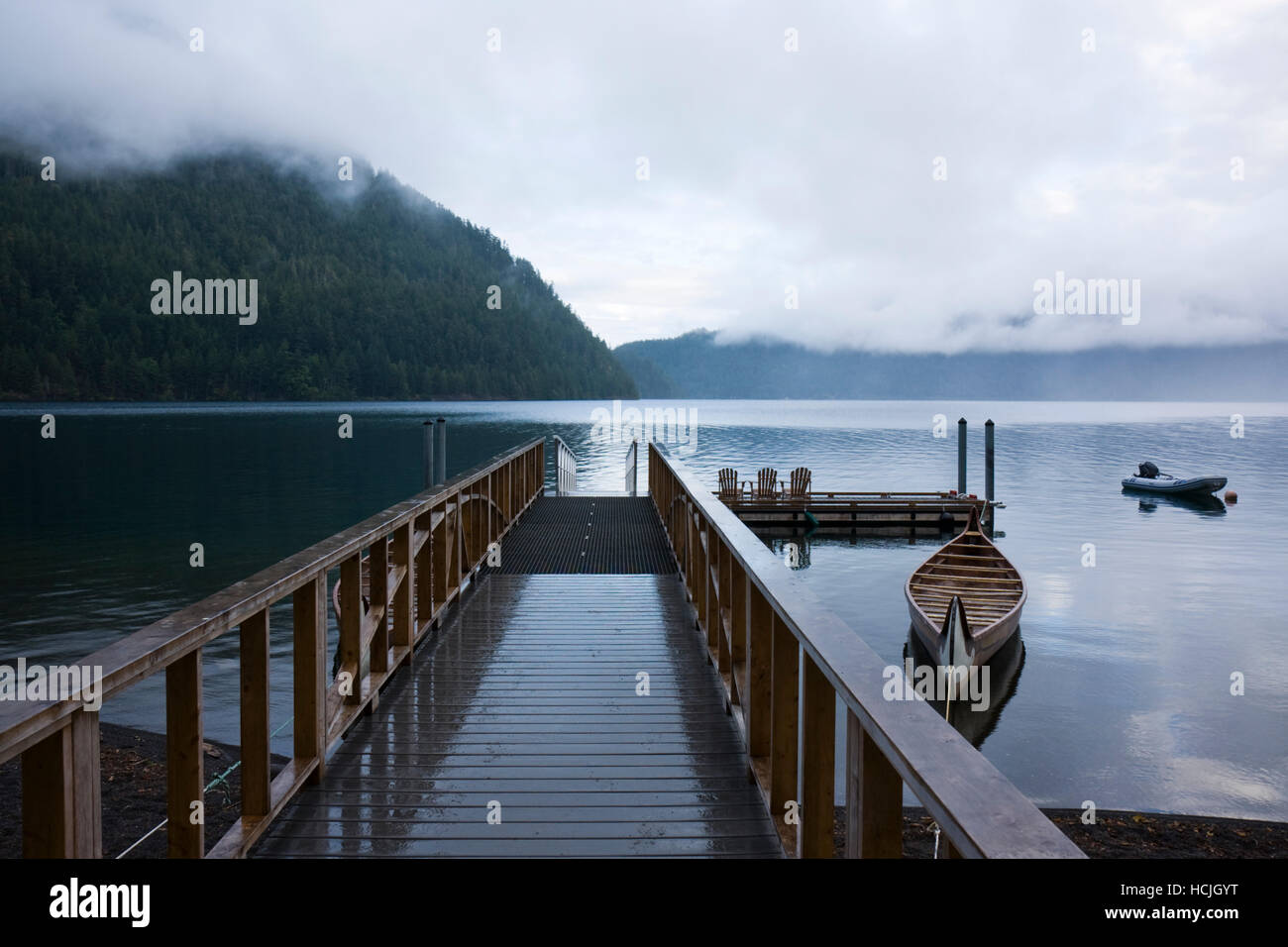 A boat pier extends out on a misty morning onto Lake Crescent at the ...