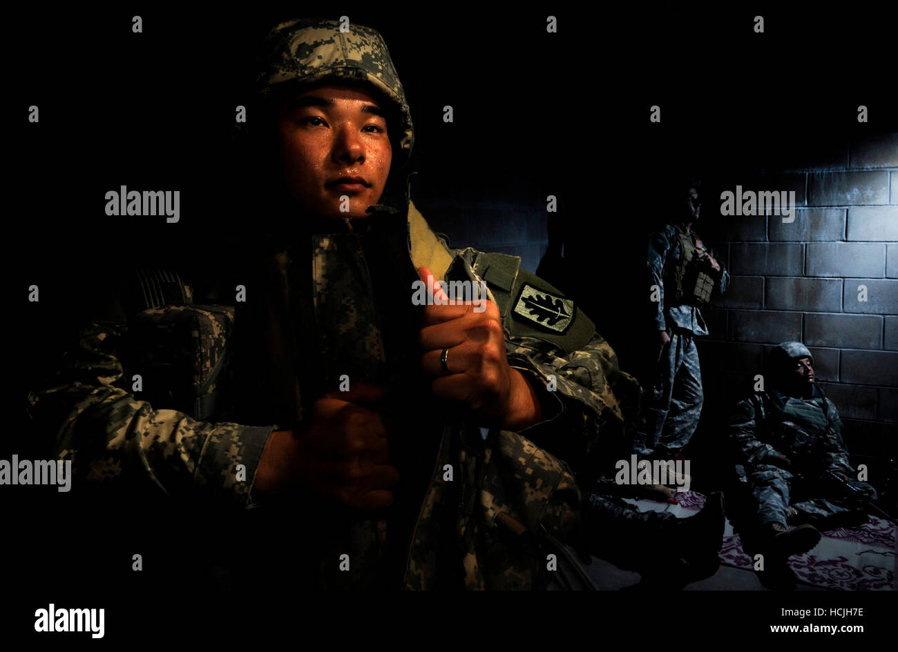 A soldier demonstrates how to properly put on personal body armor ...