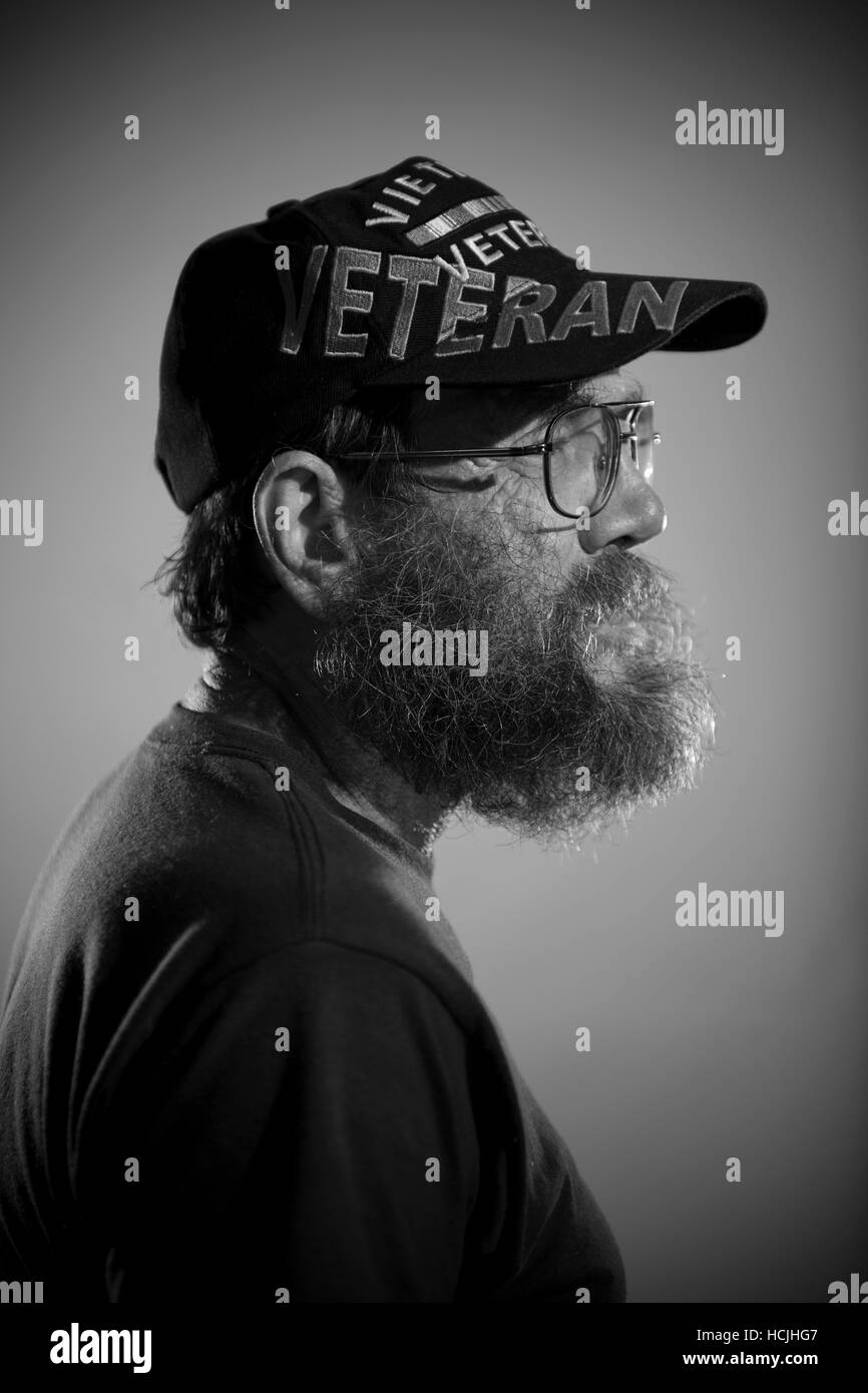 A male veteran wears a war related ball cap with thick glasses and a ...
