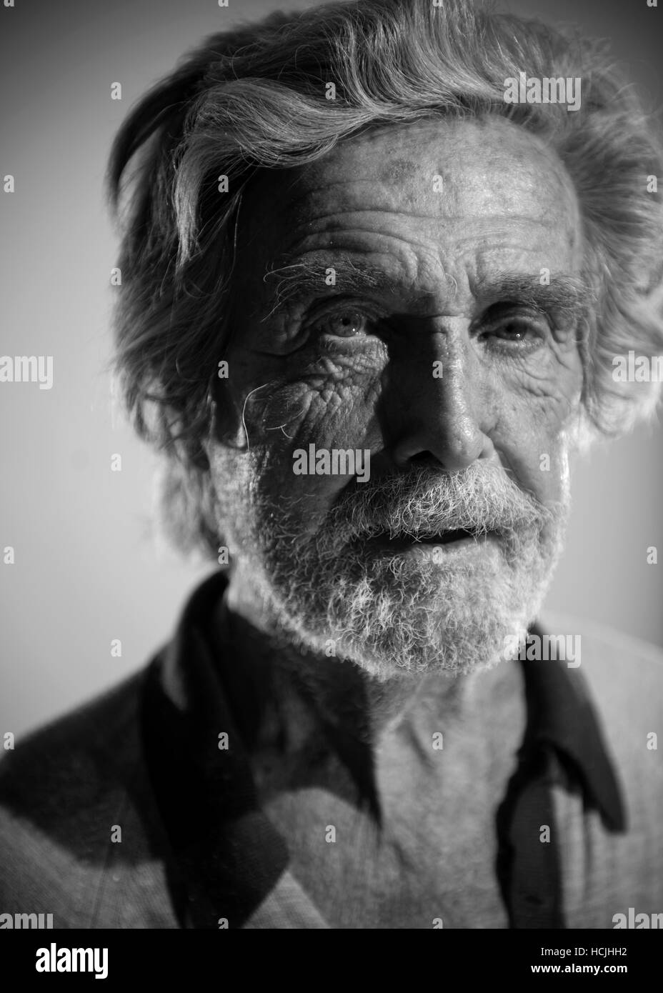 A male veteran with a full beard and mustache wears his hair long and ...