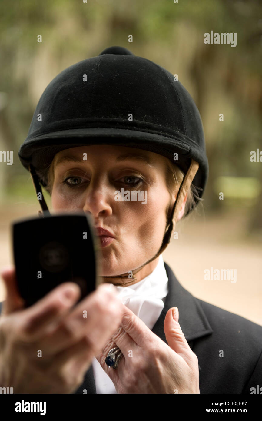 A woman fixes her make-up and lipstick before a traditional fox hunt ...