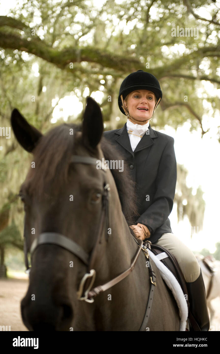 A woman smiles as she sits atop her horse before a traditional fox hunt ...
