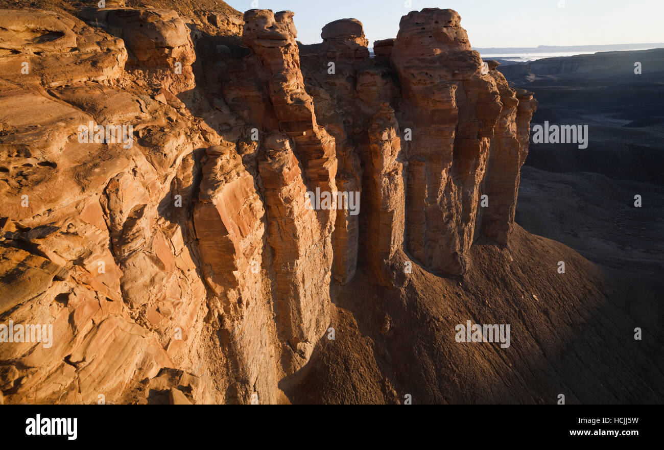 Sunrise strikes the dramatic columnar sandstone walls of a deep canyon ...