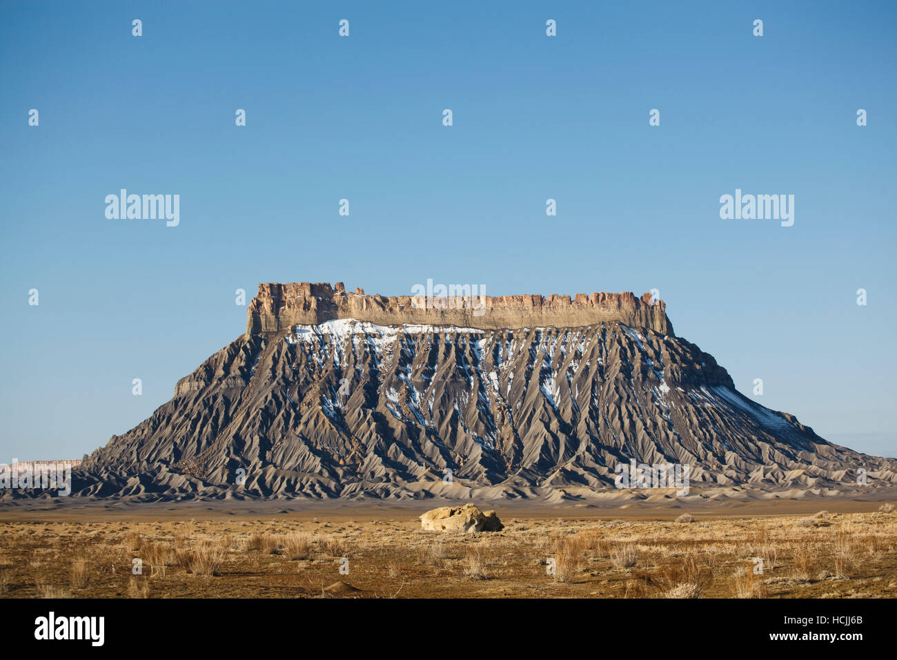 Factory Butte stands amidst mancos shale badlands near Hanksville, Utah ...