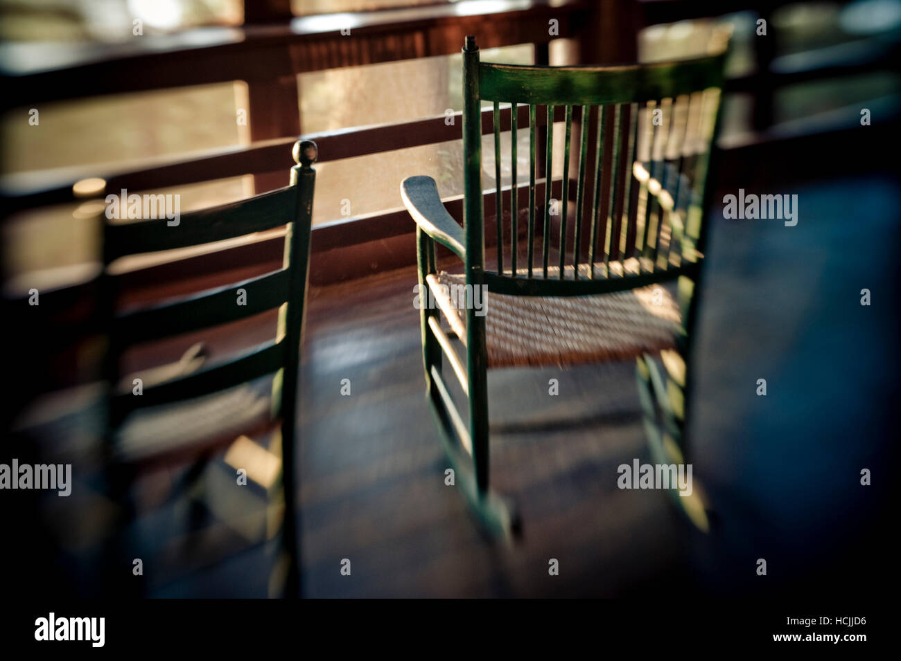 Wooden rocking chairs on a deck in the early morning by the shore of ...