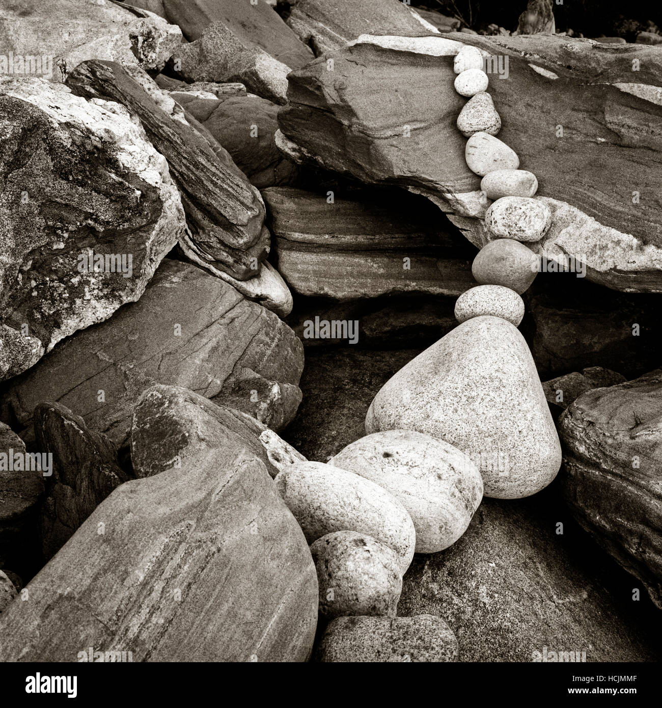 A grouping of rocks made smooth from the pounding surf is arranged in a ...