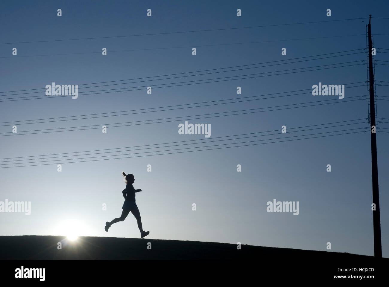 Minimalistic silhouette of a young woman running on the horizon at ...