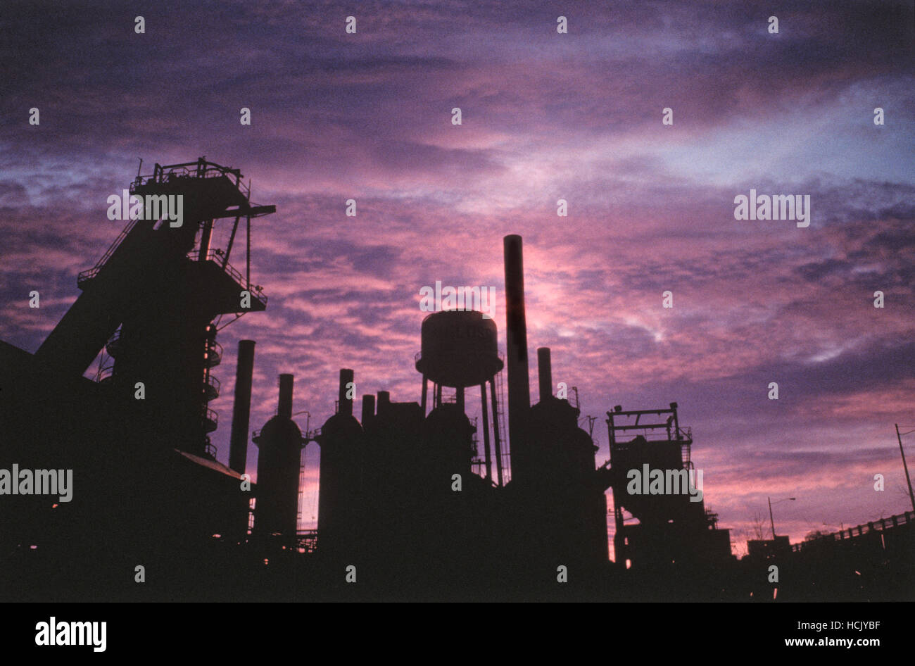 A dramatic sunset over an outdated and long closed steel mill in ...