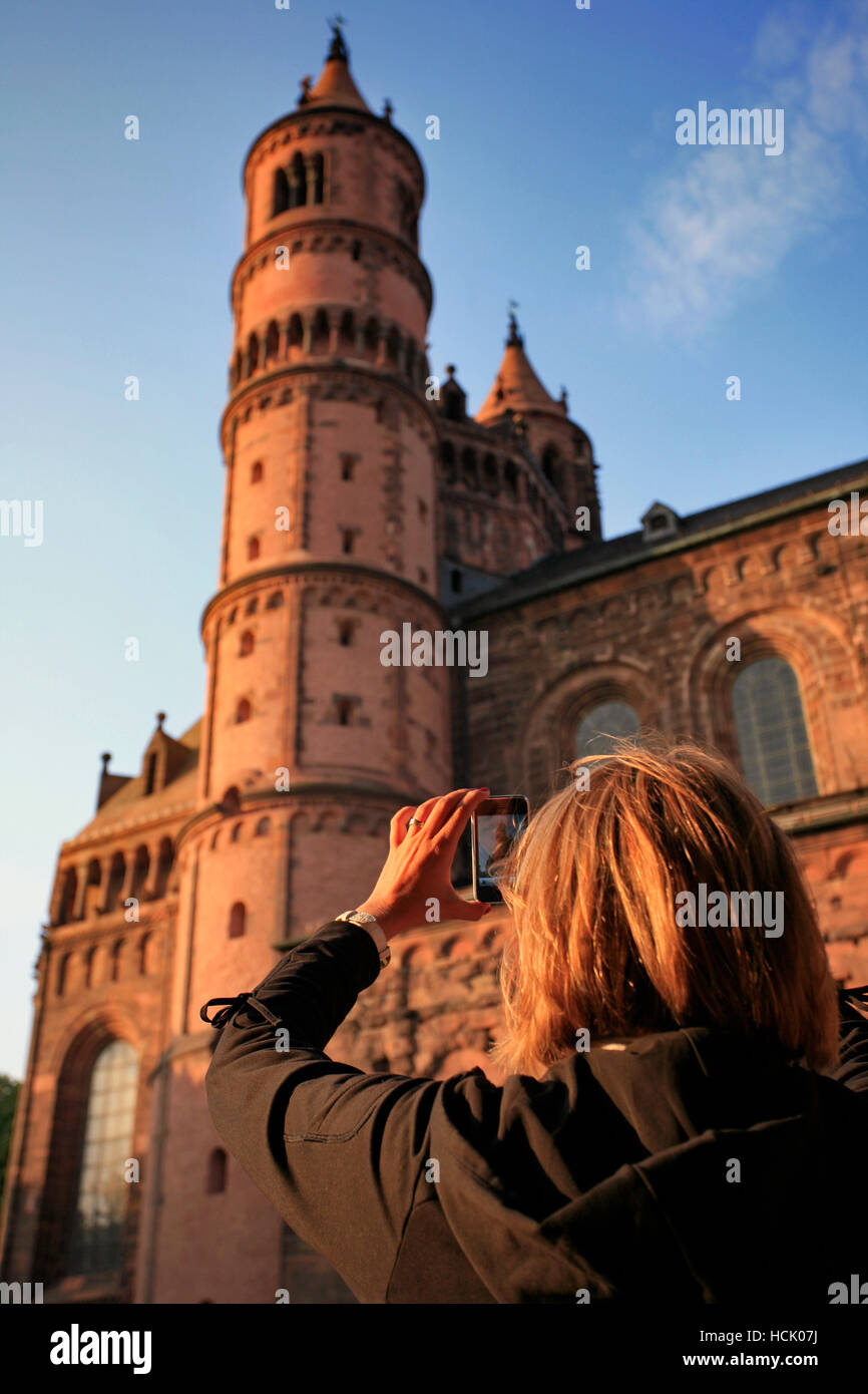 Woman photographs the Worms (Germany) cathedral using an iPhone. The ...