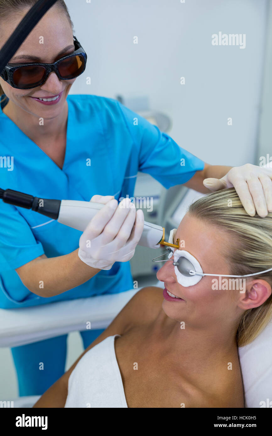 Woman receiving laser epilation treatment on her forehead Stock Photo ...