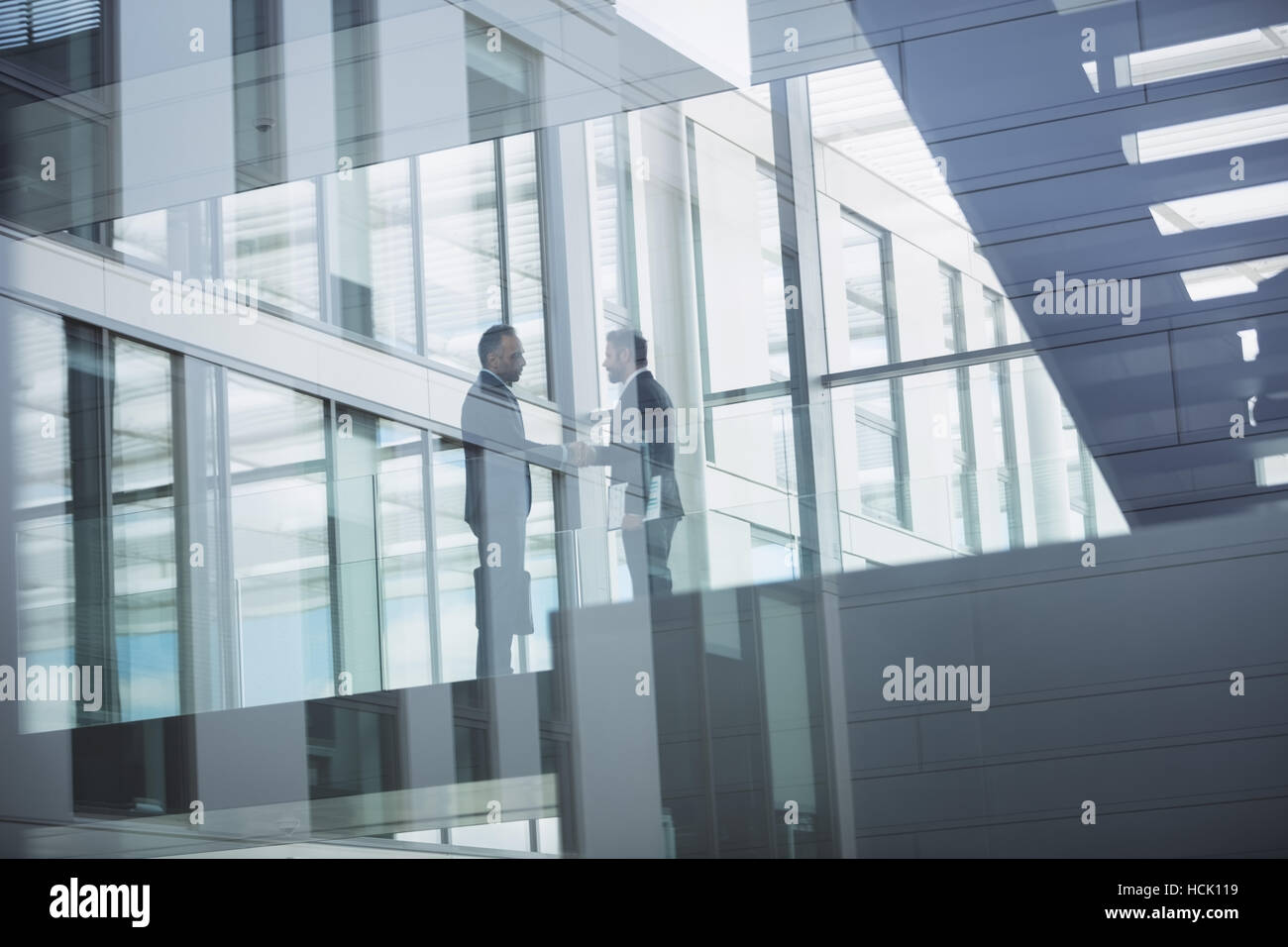Businessman greeting a colleague inside office building Stock Photo - Alamy