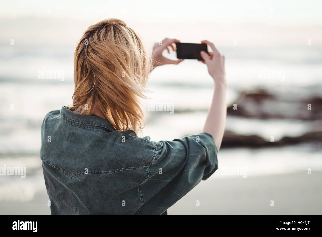 Woman clicking photographs with mobile phone Stock Photo - Alamy