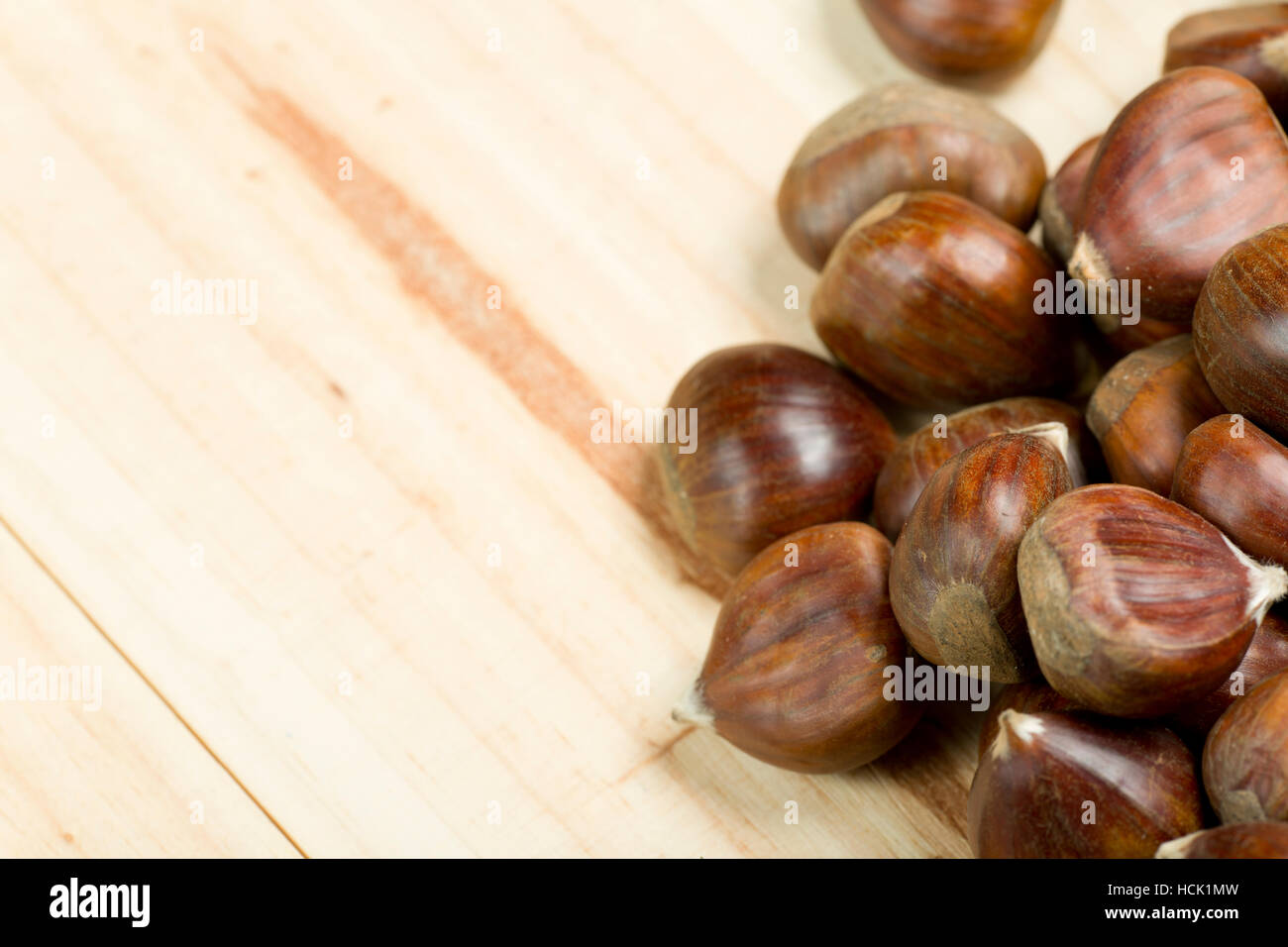 Chestnuts on pine wood background, illuminated with studio flax ...