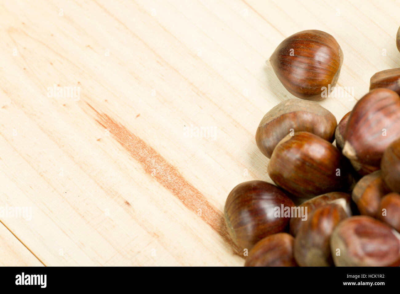 Chestnuts on pine wood background, illuminated with studio flax ...