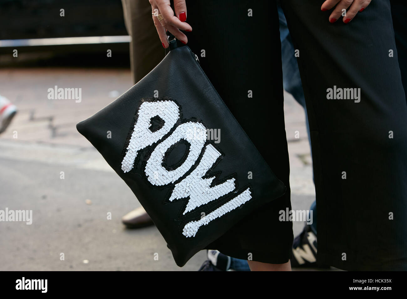 Woman with black leather bag with Pow! writing in white before ...
