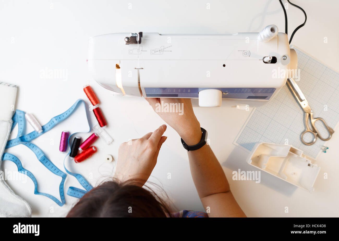 Girl sets up sewing machine Stock Photo - Alamy