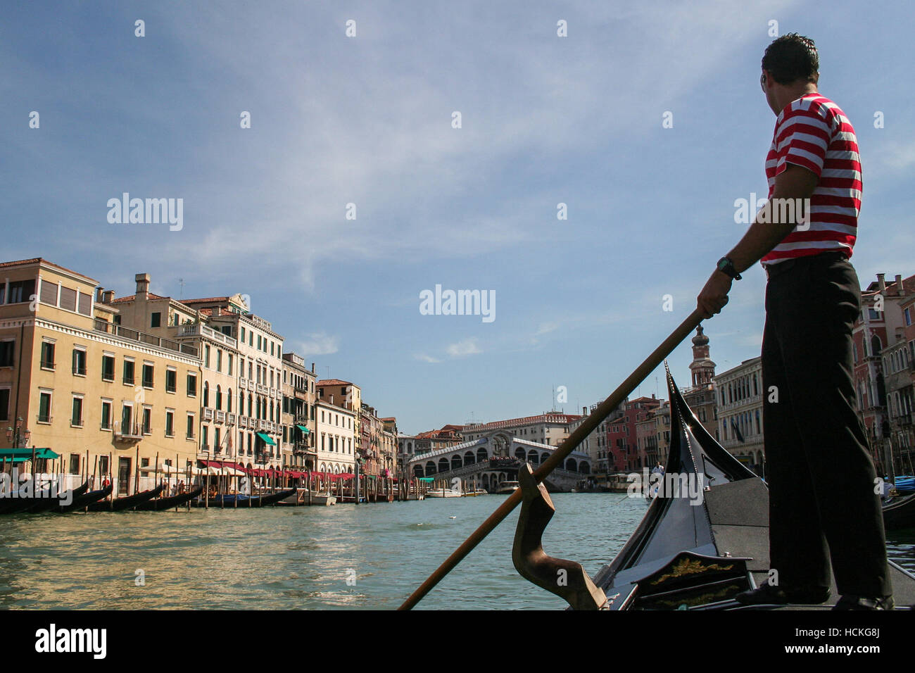Gondolier in his gondola along the Grand Canal and in the background ...