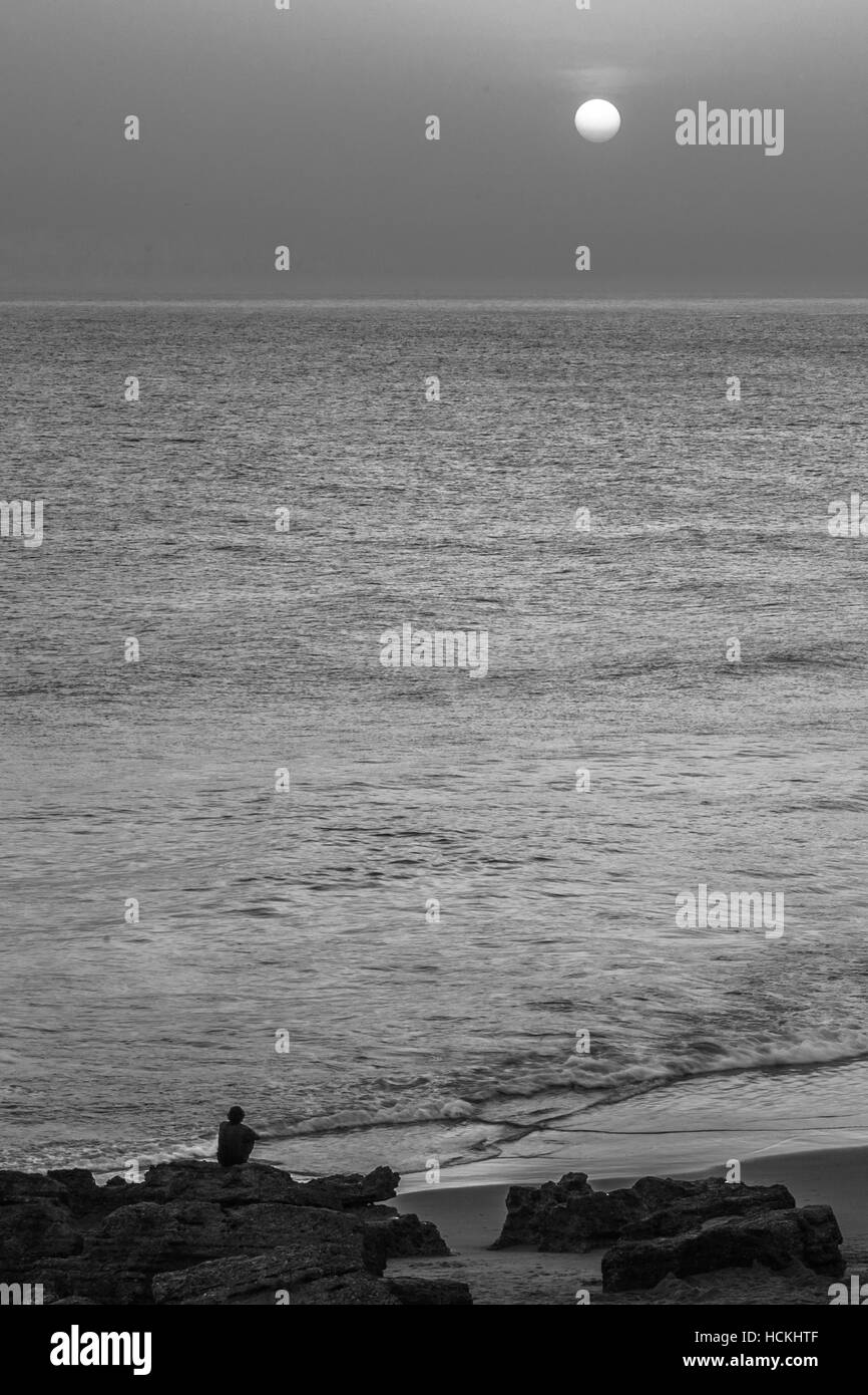 Person watching as the sun goes down Stock Photo - Alamy