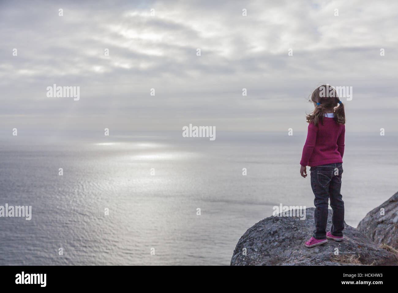 Girl enjoying a spectacular view of the sea with a few rays of sun ...