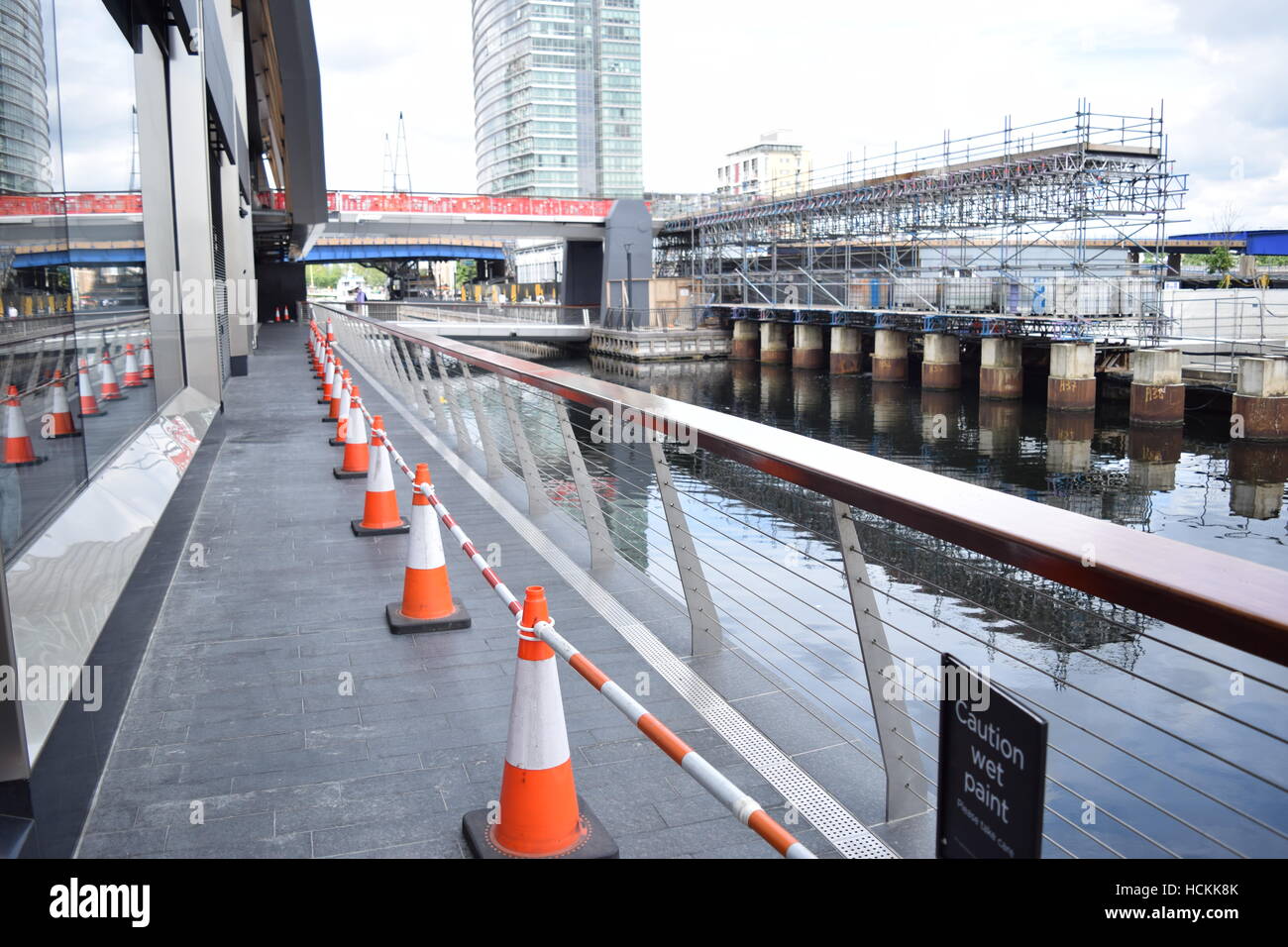 Line of orange and white cones on a high bridge with modern skyscrapers ...