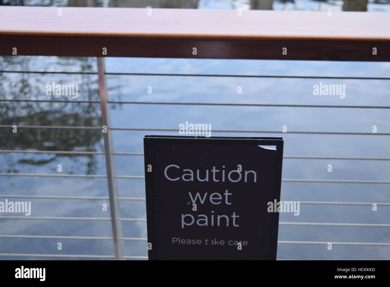 Caution sign on a metallic bridge railing with a river background Stock ...