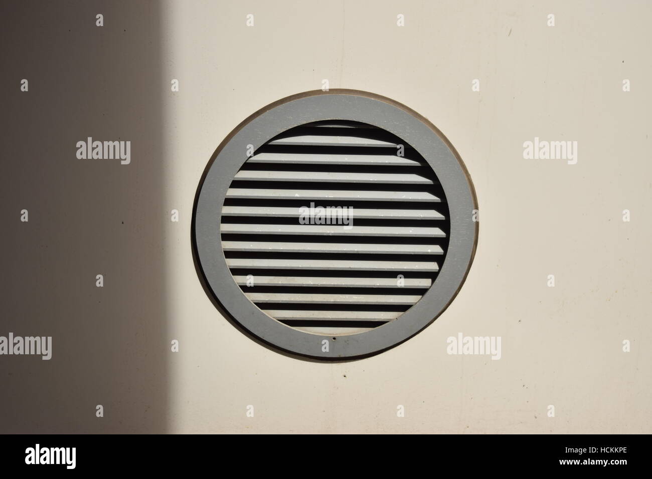 Circular air vent on a white wall with a side shadow Stock Photo - Alamy