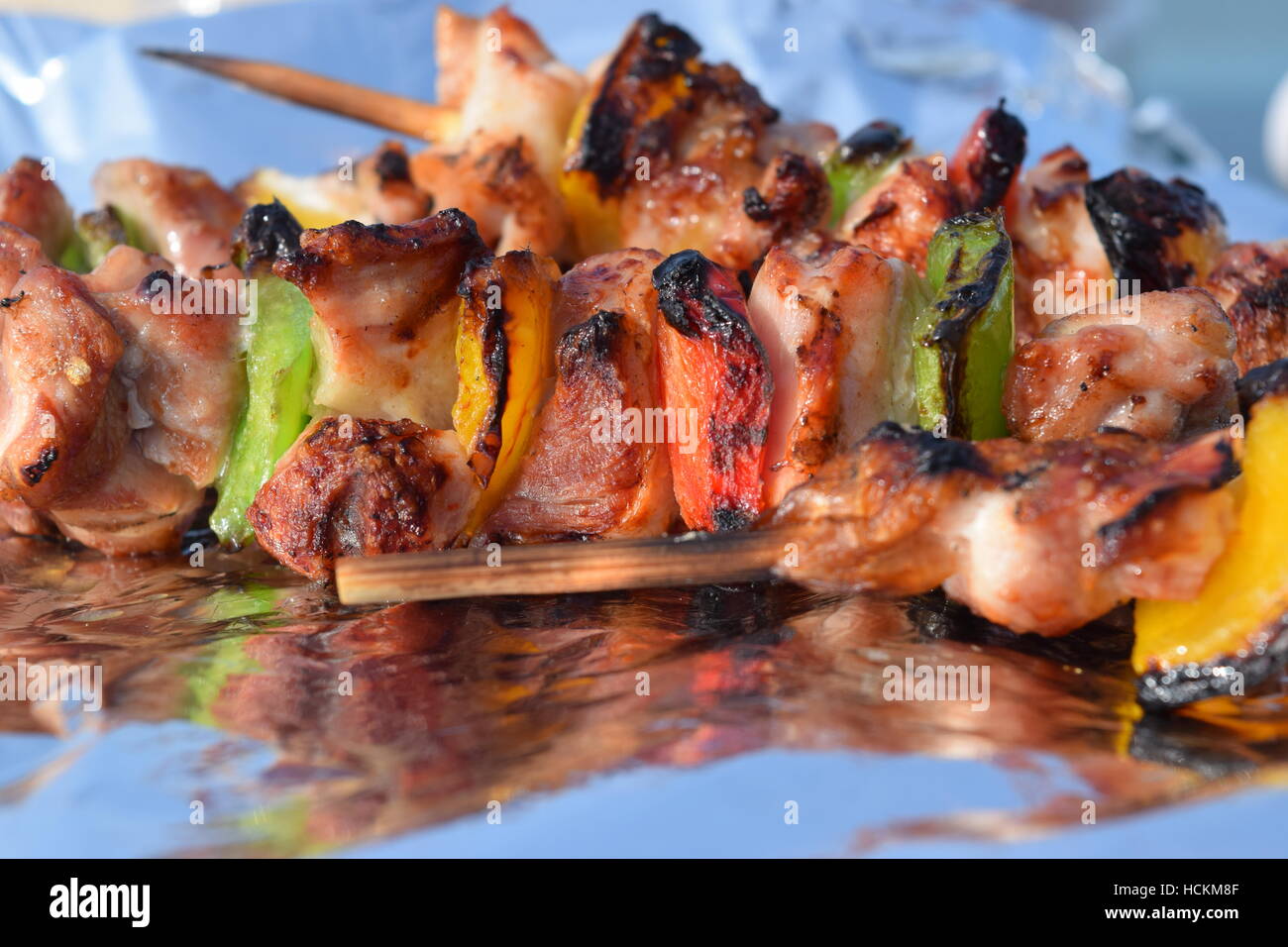 Roasted barbecue skewers on a strip of tin foil Stock Photo - Alamy