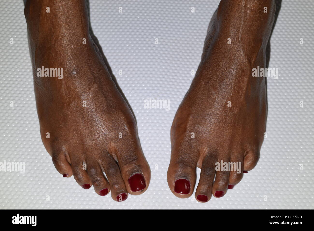 Two female feet turned outwards on white flooring Stock Photo - Alamy