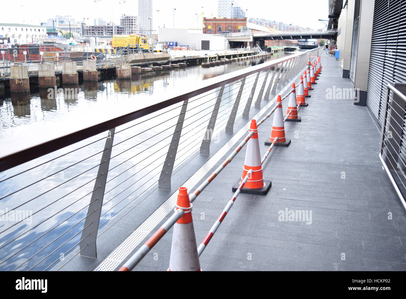 Long line of orange and white cones on the side of a bridge Stock Photo ...