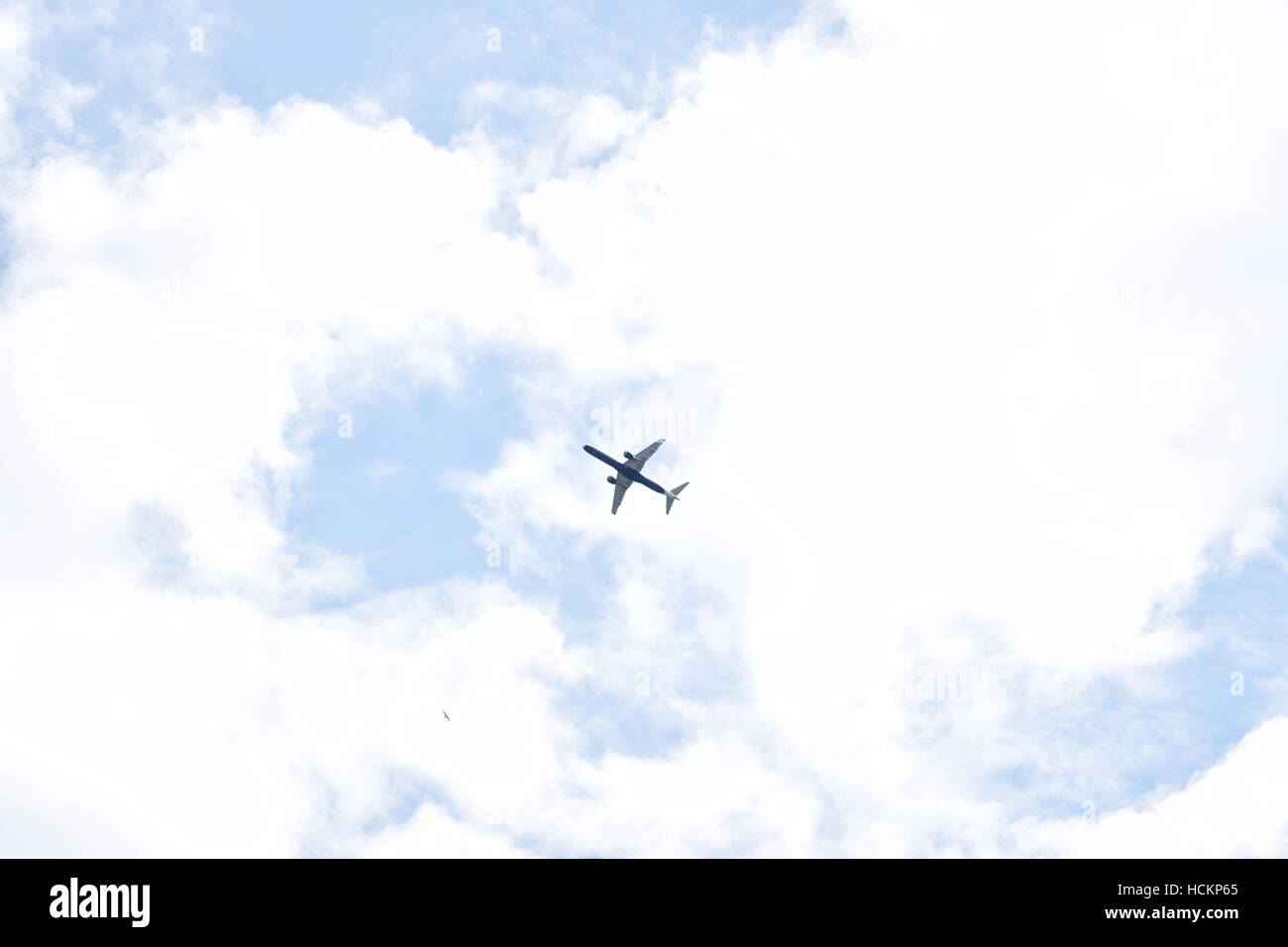 Upward view of a faraway plane in the sky among the clouds Stock Photo ...