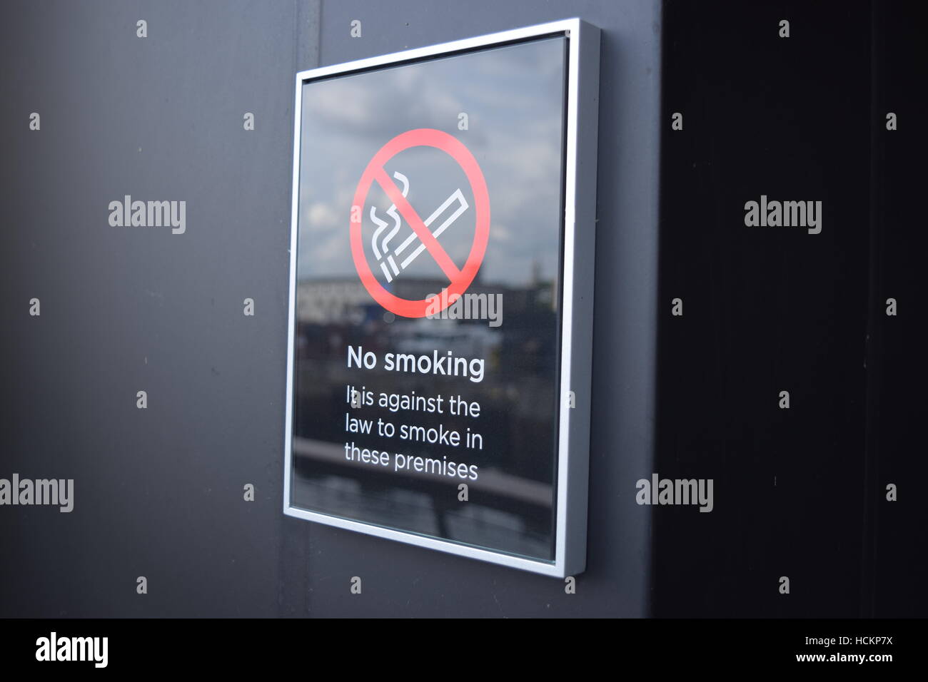 Shiny new no smoking sign outside a building Stock Photo - Alamy