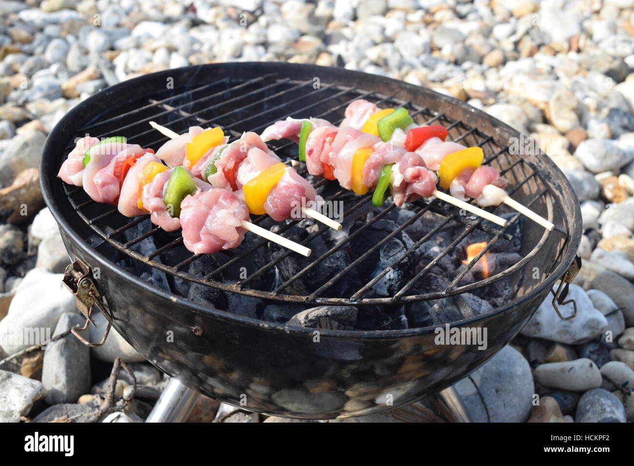 Raw barbecue skewers grilling outdoors Stock Photo - Alamy