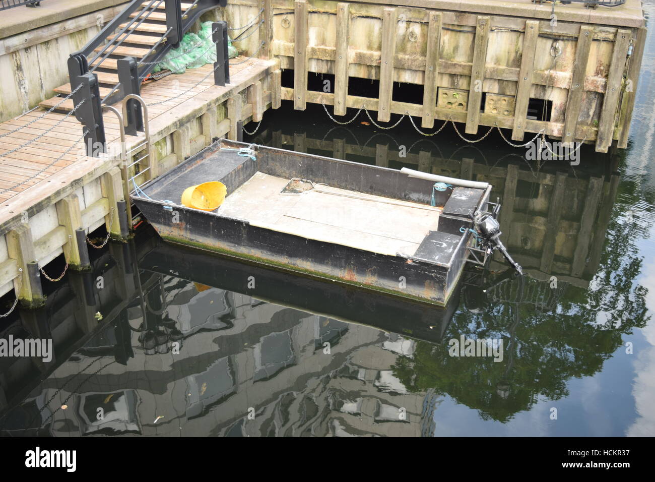 Small black boat floating on the water surface Stock Photo - Alamy