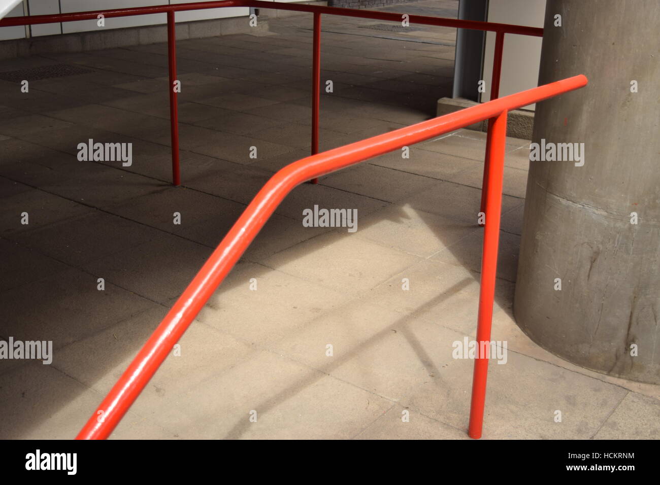 Red metal railing going down leading to the street Stock Photo - Alamy