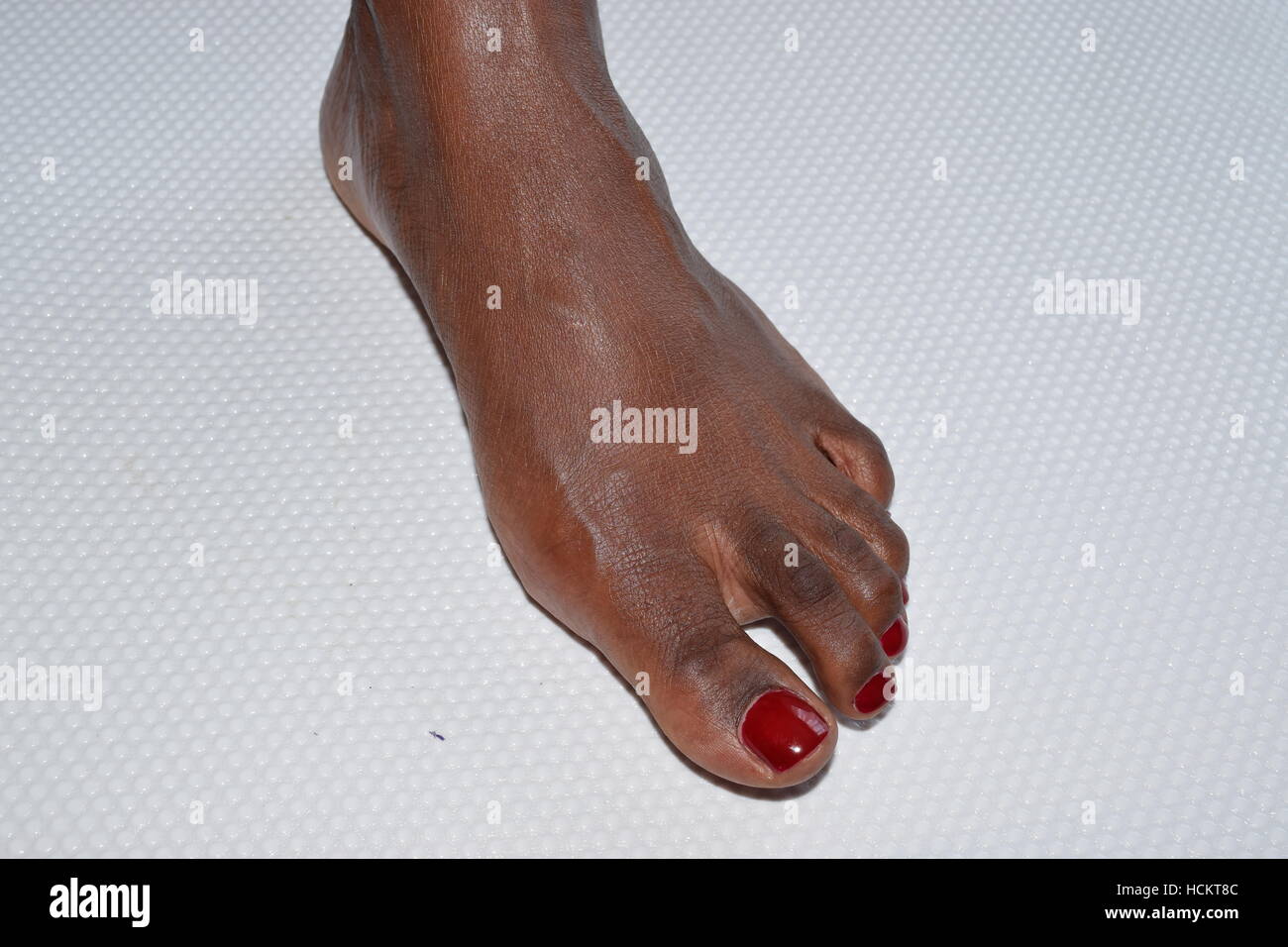 Clean pedicured foot wearing red nail polish Stock Photo - Alamy