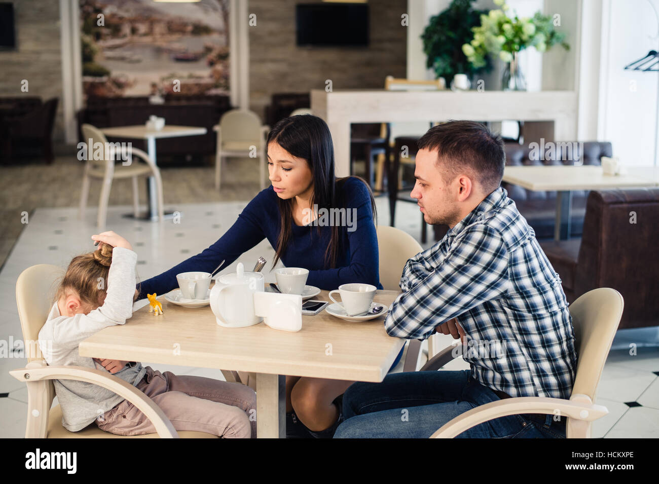 Ordinary family of three with little daughter and father mother giving ...