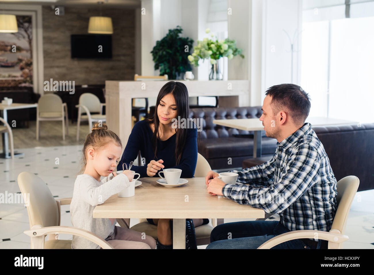 Family sitting together at table in a restaurant Stock Photo - Alamy