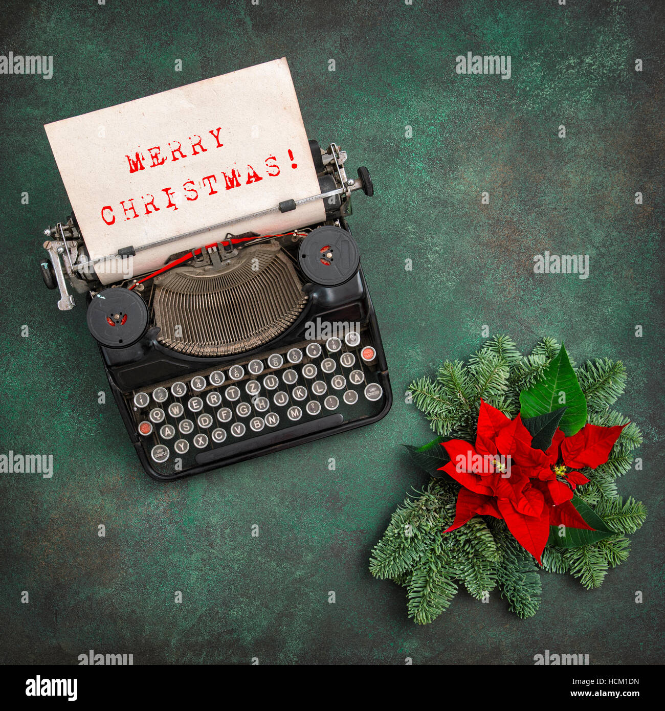Vintage typewriter with Christmas decoration and red poinsettia flowers ...