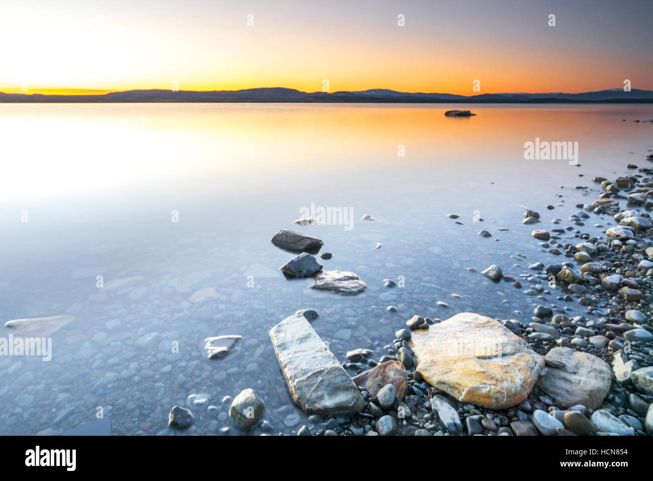 Stone lake with sunrise background Stock Photo - Alamy