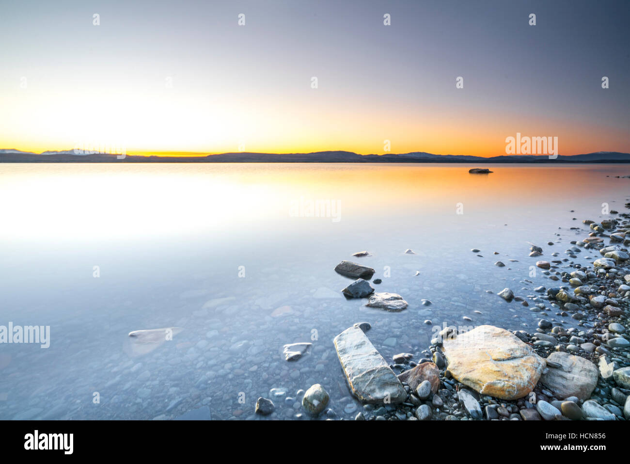 Stone lake with sunrise background Stock Photo - Alamy